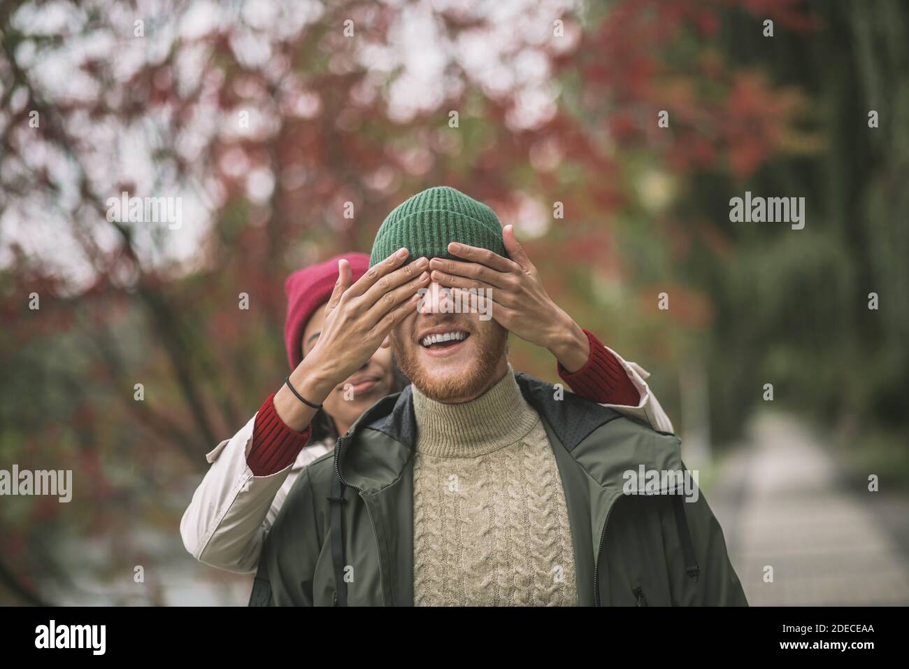 Woman closing her boyfriends eyes while walking Stock Photo - Alamy