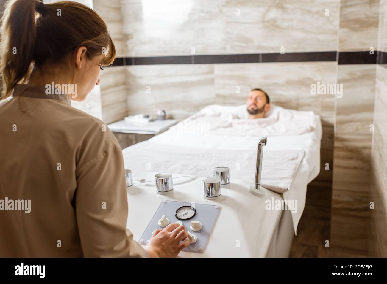 Man relaxing during a medical treatment at the bath filled with carbon ...