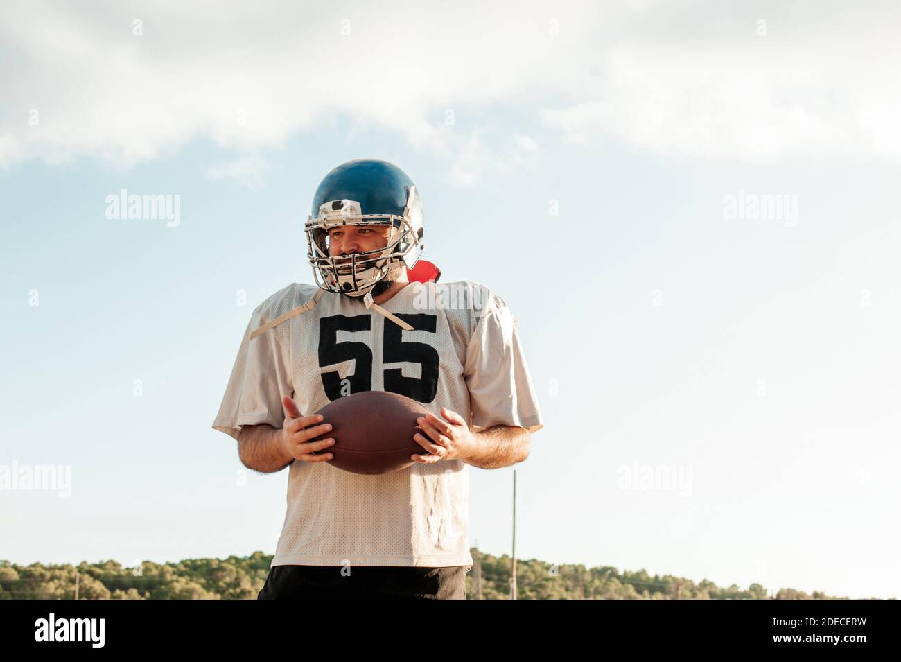 American football player holding ball portrait Stock Photo - Alamy