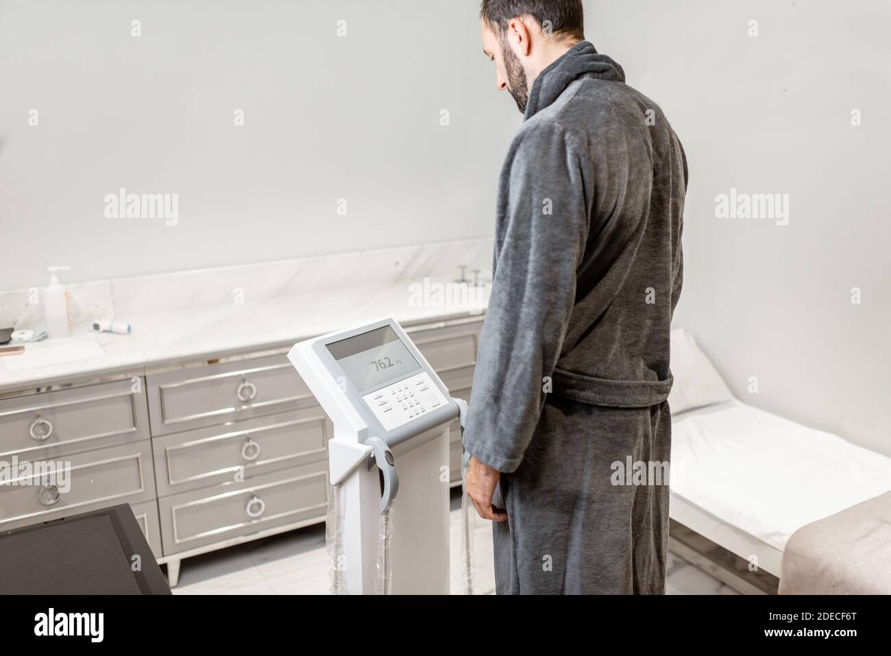 Man measuring body composition balance, standing on the medical scales ...