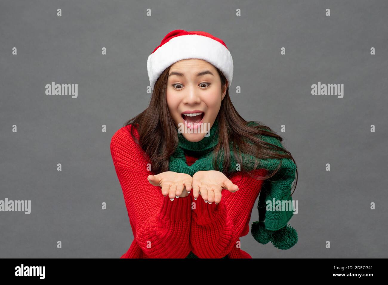 Studio portrait of a young gleeful asian woman wearing christmas themed ...