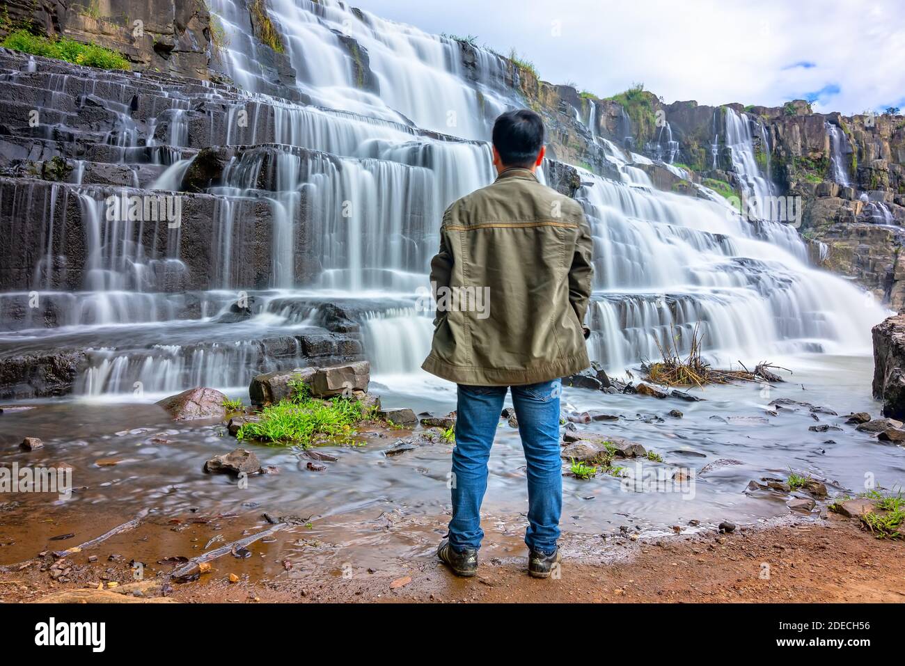 Traveler Man watching beautiful waterfall majestic scenery as a way to ...