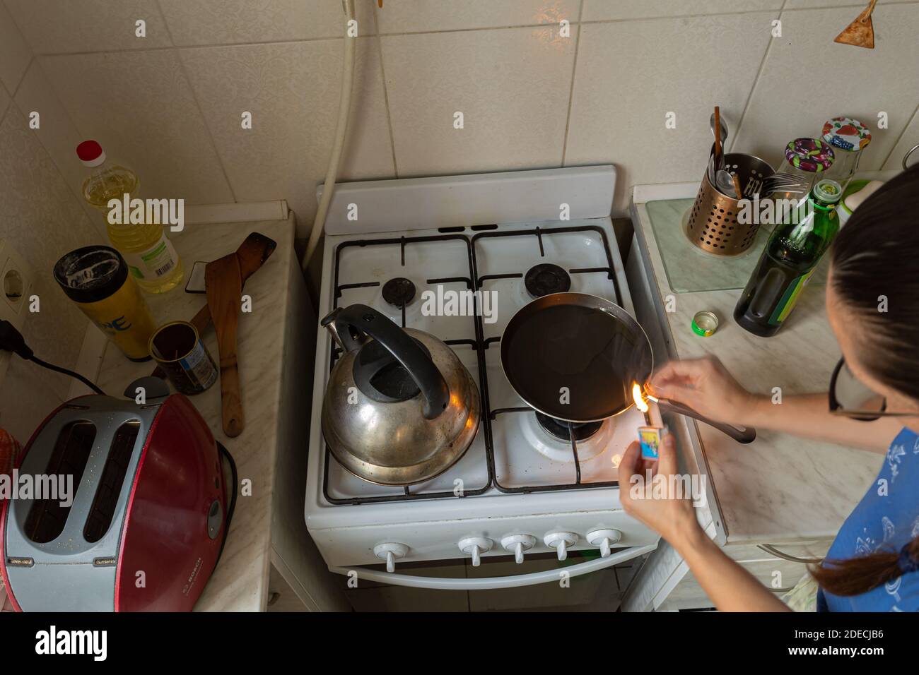 Woman lights the gas stove with matches Stock Photo - Alamy