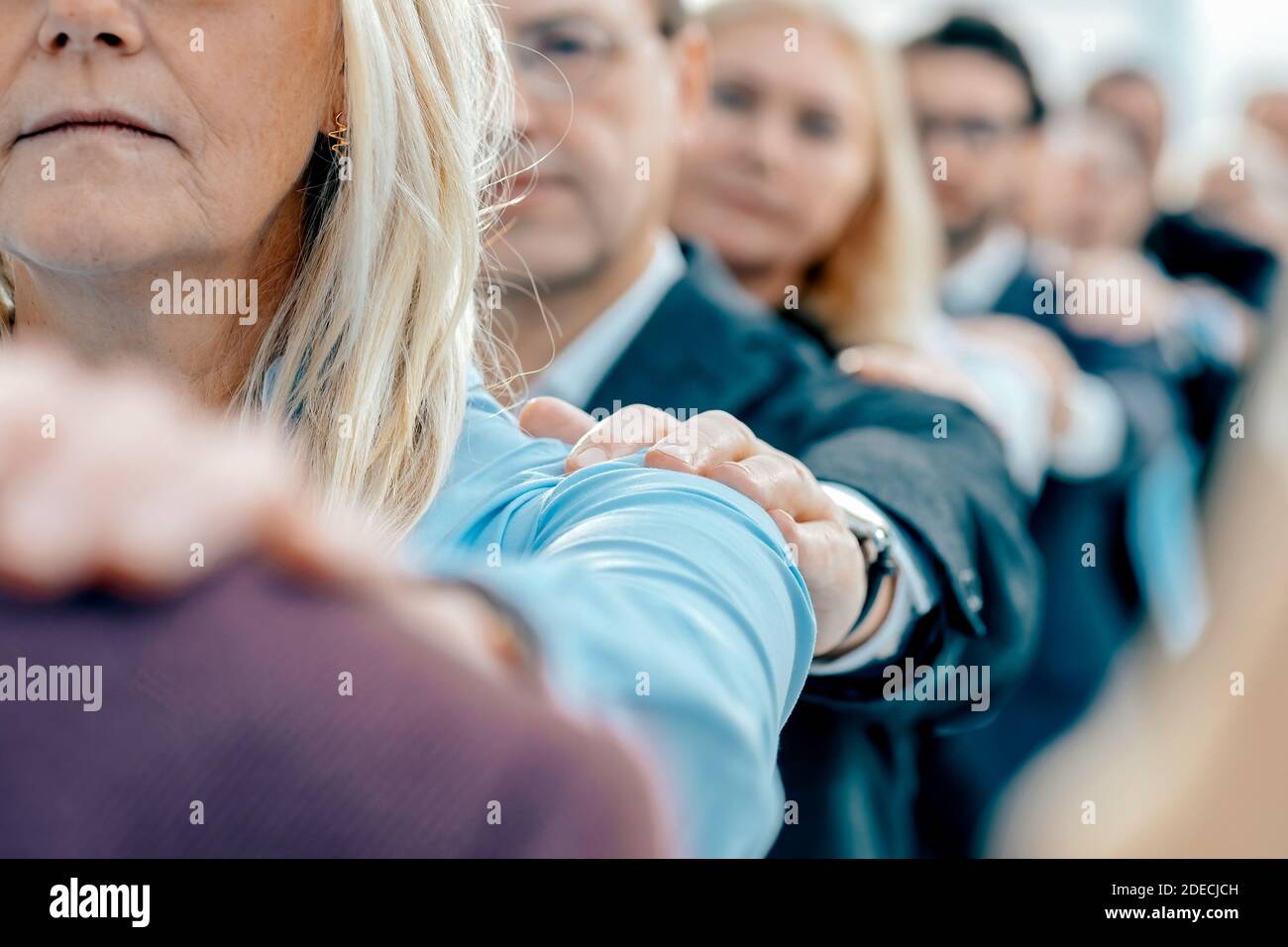 close up. corporate employees supporting each other Stock Photo - Alamy