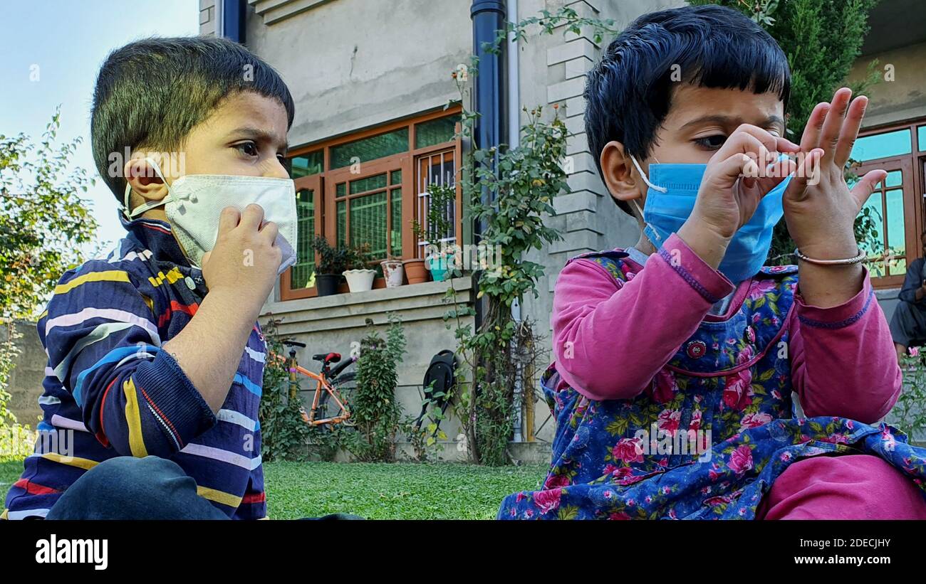 Masked handsome kids are playing running enjoying and smiling at home ...