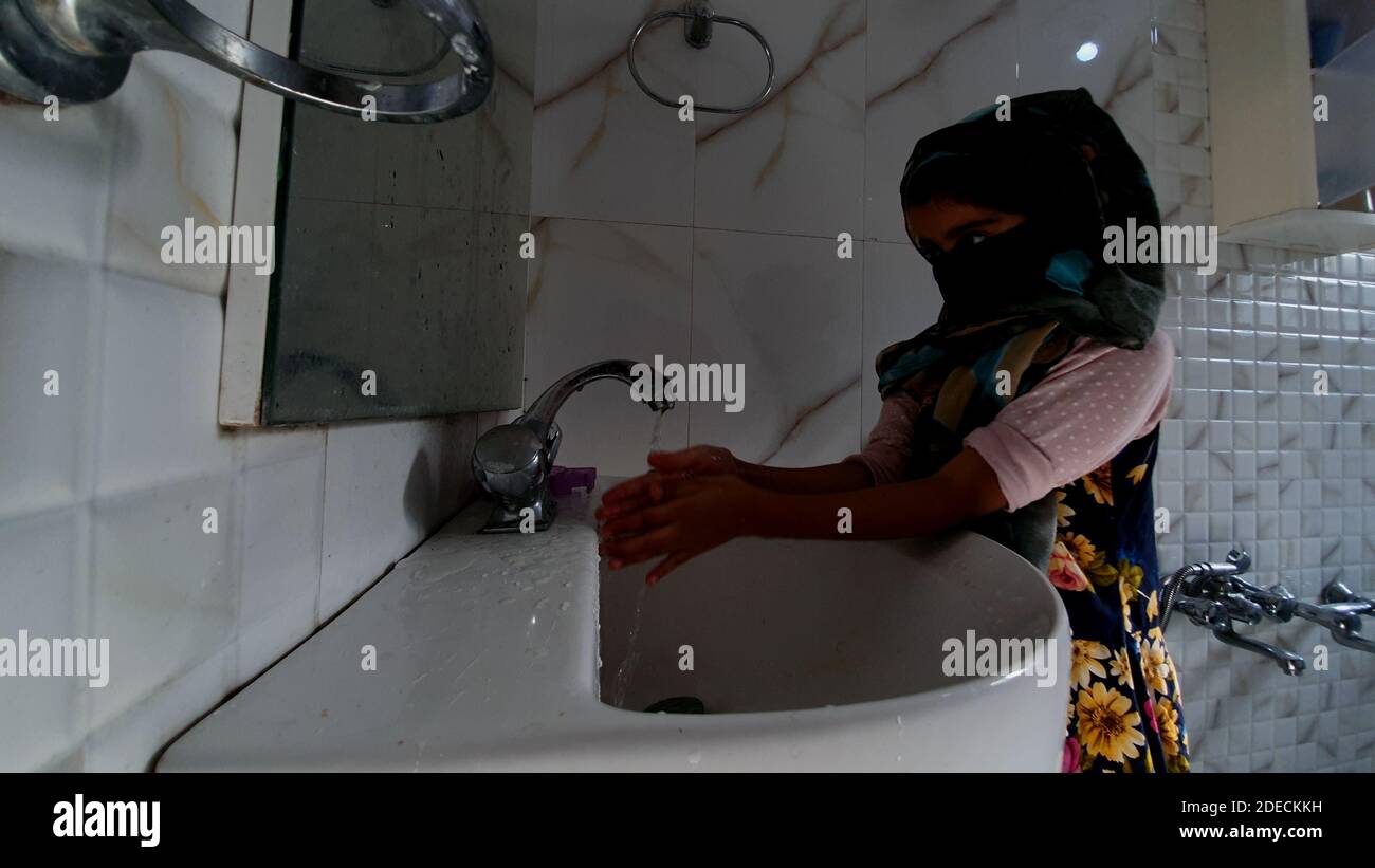 Washing hands in bathroom by masked Children during coronavirus ...