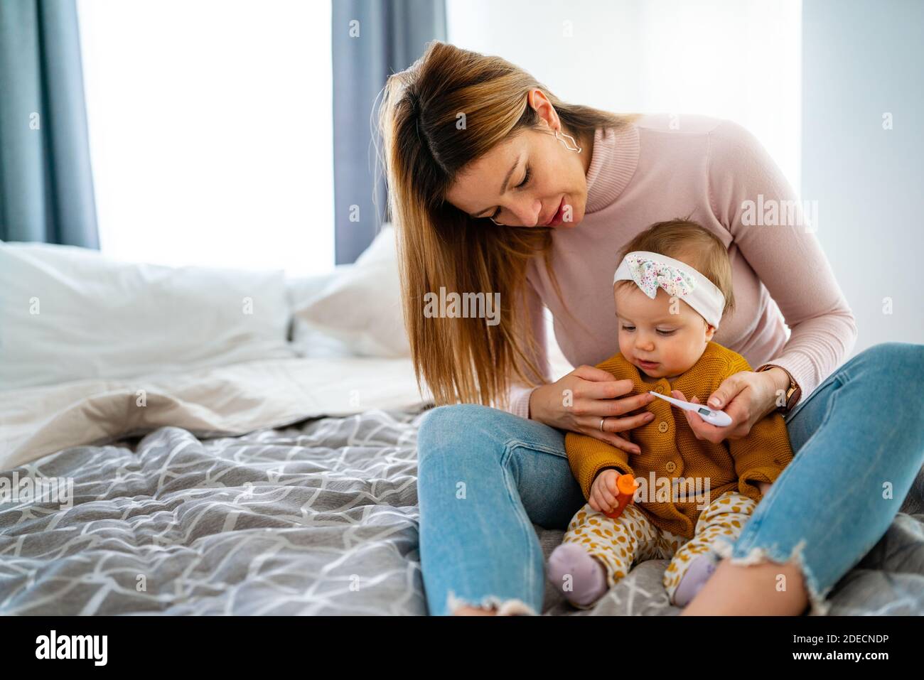 Mother measuring temperature of her ill kid. Sick child with high fever, mother holding ...