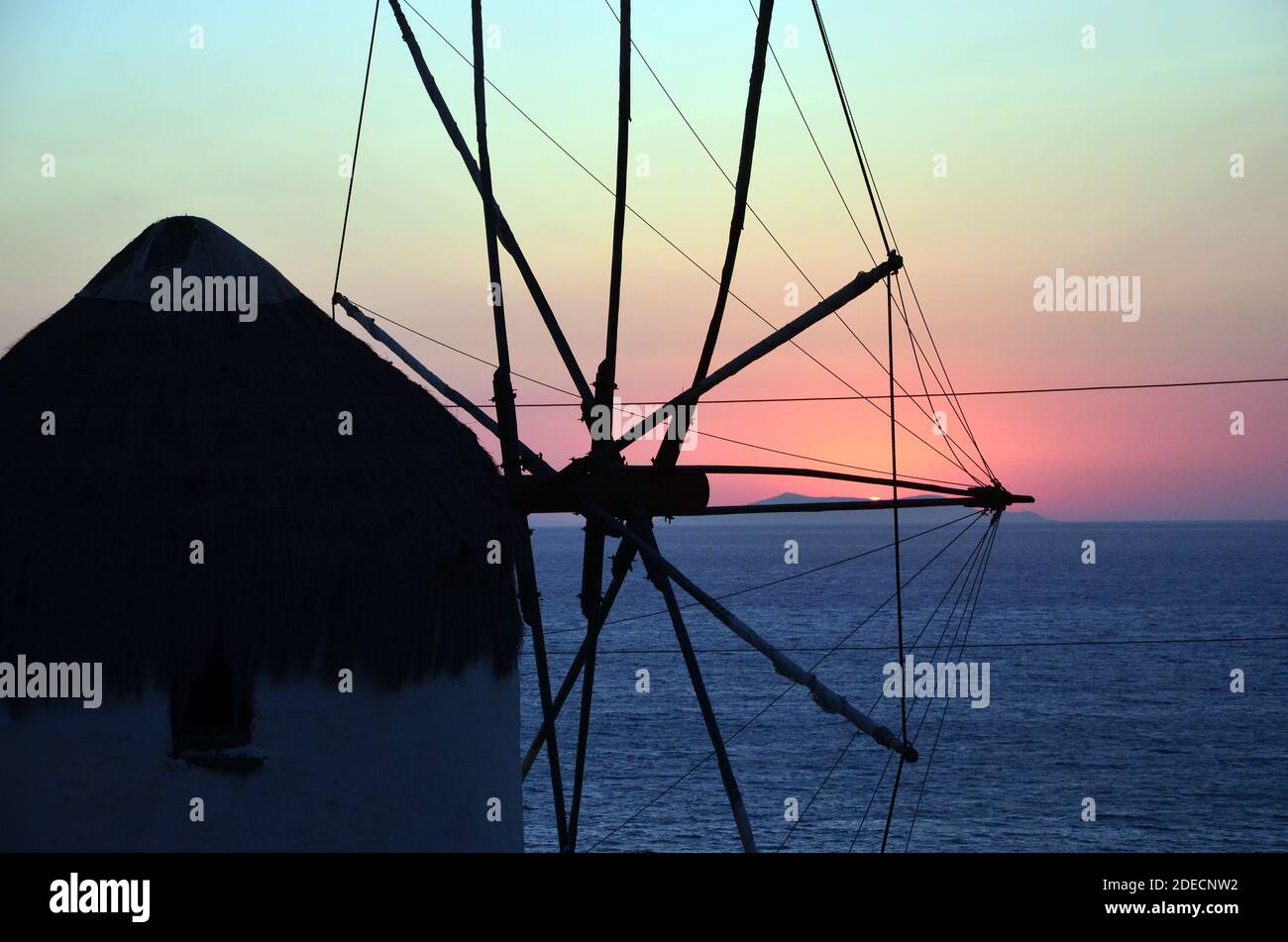 Sunset at the sea and windmill Stock Photo - Alamy