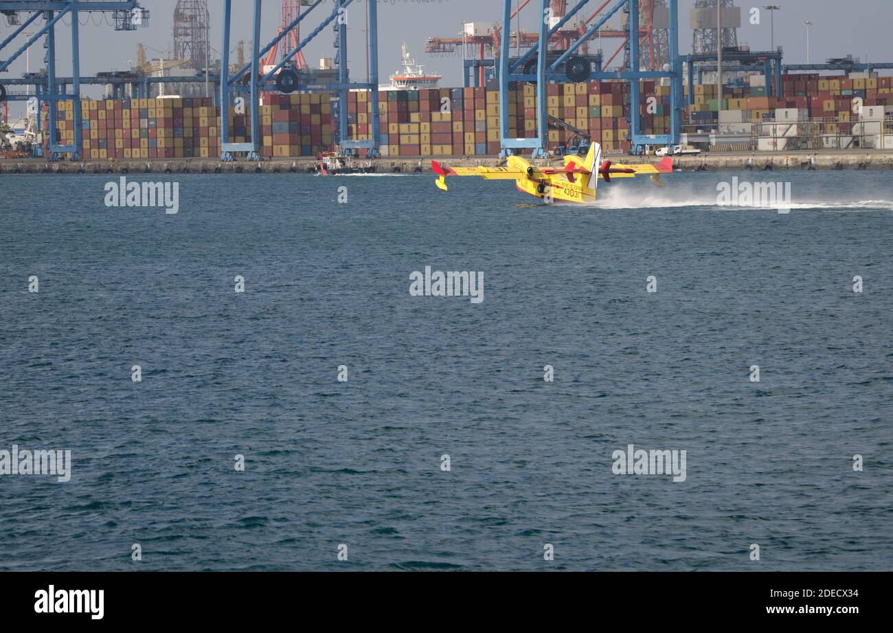 Fire-fighting plane collecting sea water to extinguish a forest fire ...