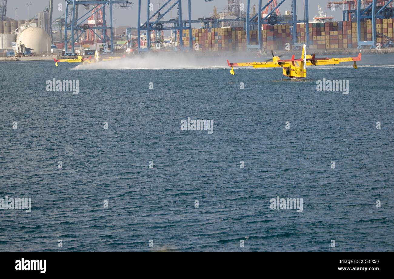 Fire-fighting planes collecting sea water to extinguish a forest fire ...