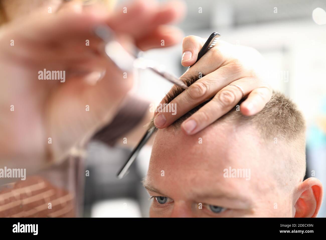 Master cuts man in beauty salon. closeup Stock Photo - Alamy
