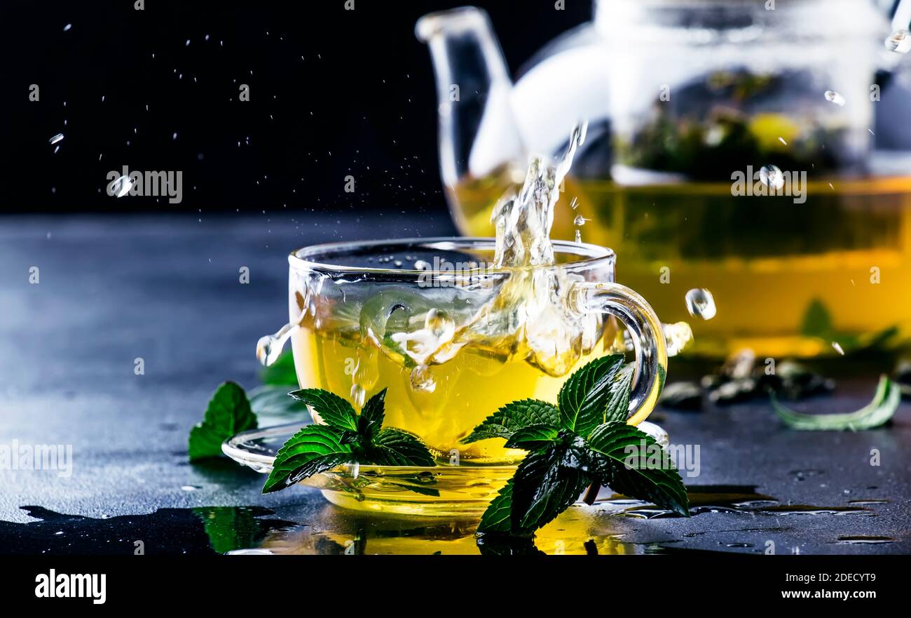 Hot chinese green tea with mint, with splash pouring from the kettle ...