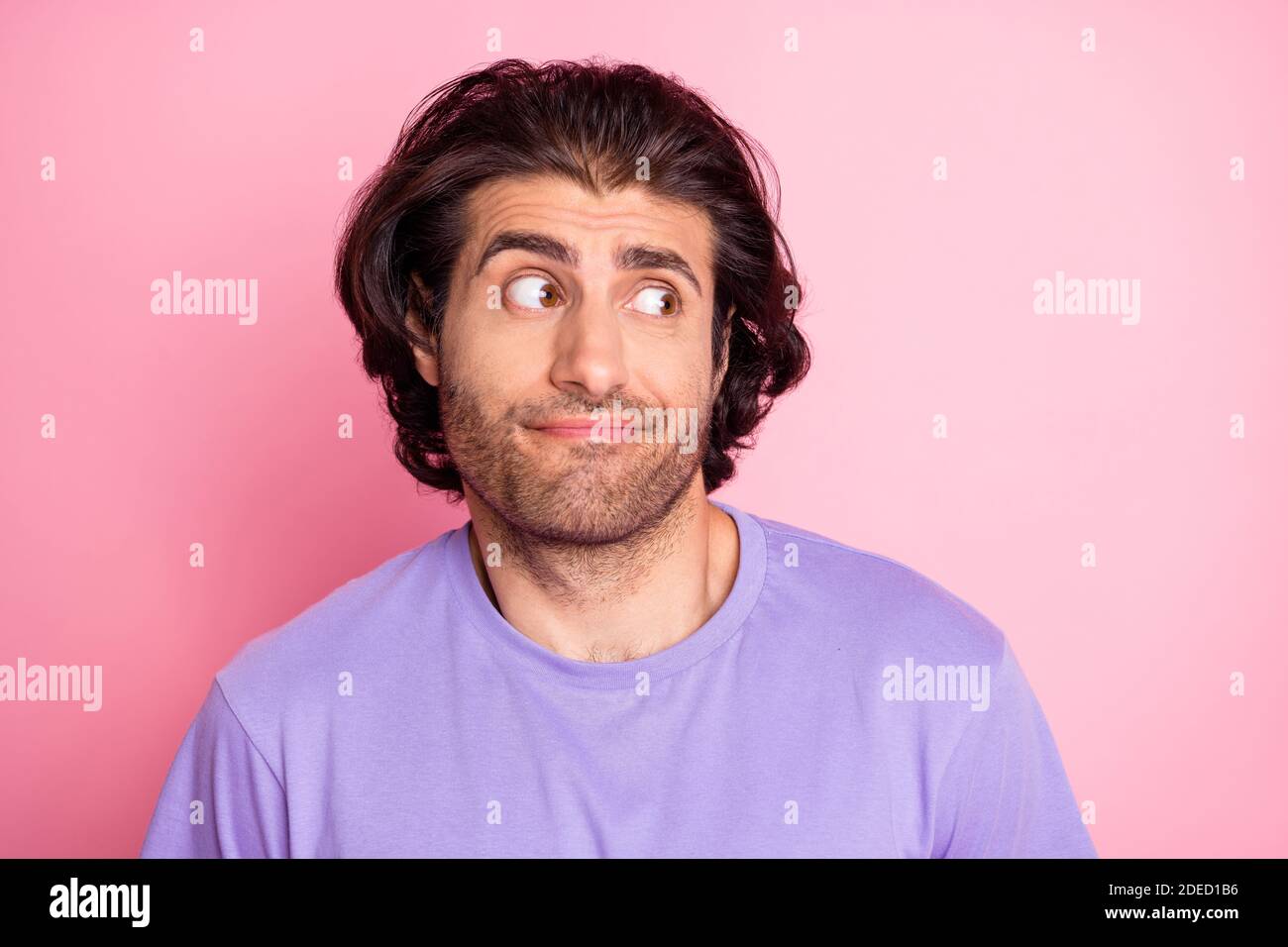 Photo of funny clueless guy look empty space wear violet shirt isolated ...