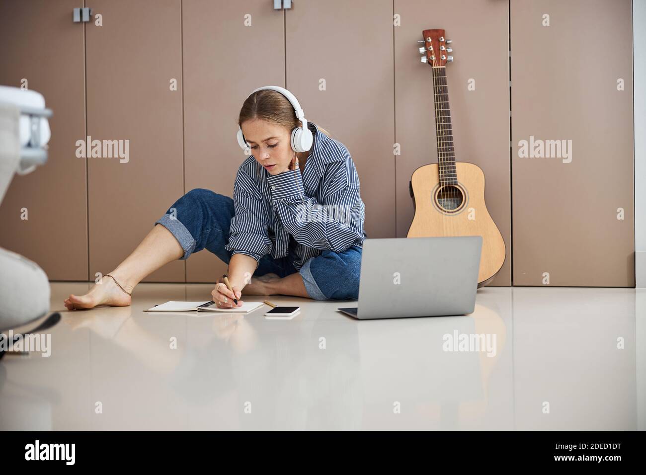 Charming female musician writing songs at home Stock Photo - Alamy