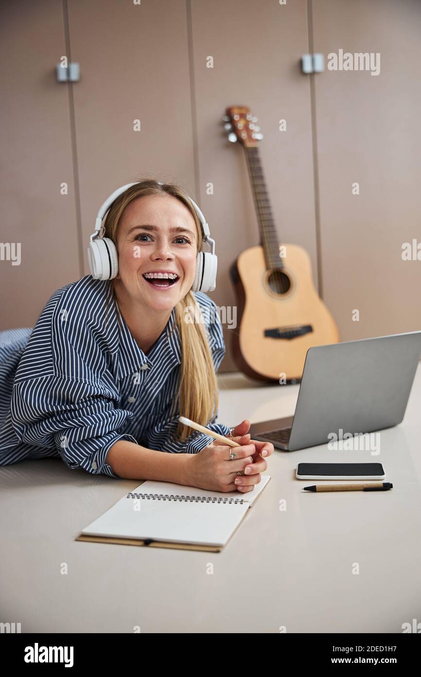 Cheerful female musician writing songs at home Stock Photo - Alamy