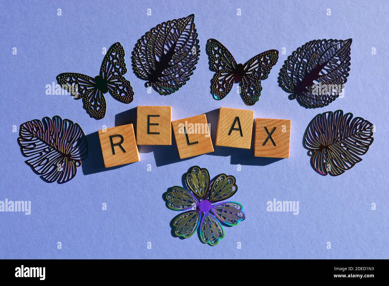 Relax, word in wooden letters surrounded by flower, leaf and butterfly ...