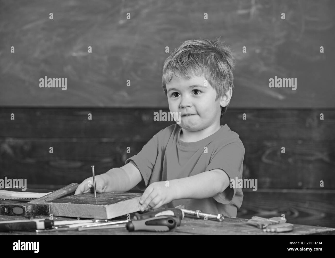 Childhood concept. Toddler on busy face plays with tools at home in ...