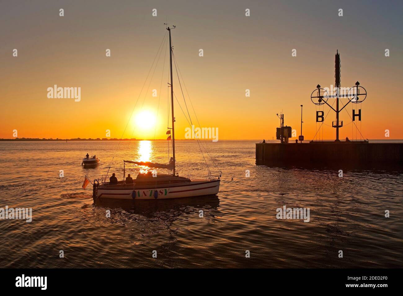 sailing boat, semaphore and signal mast of Bremerhaven at sunset ...