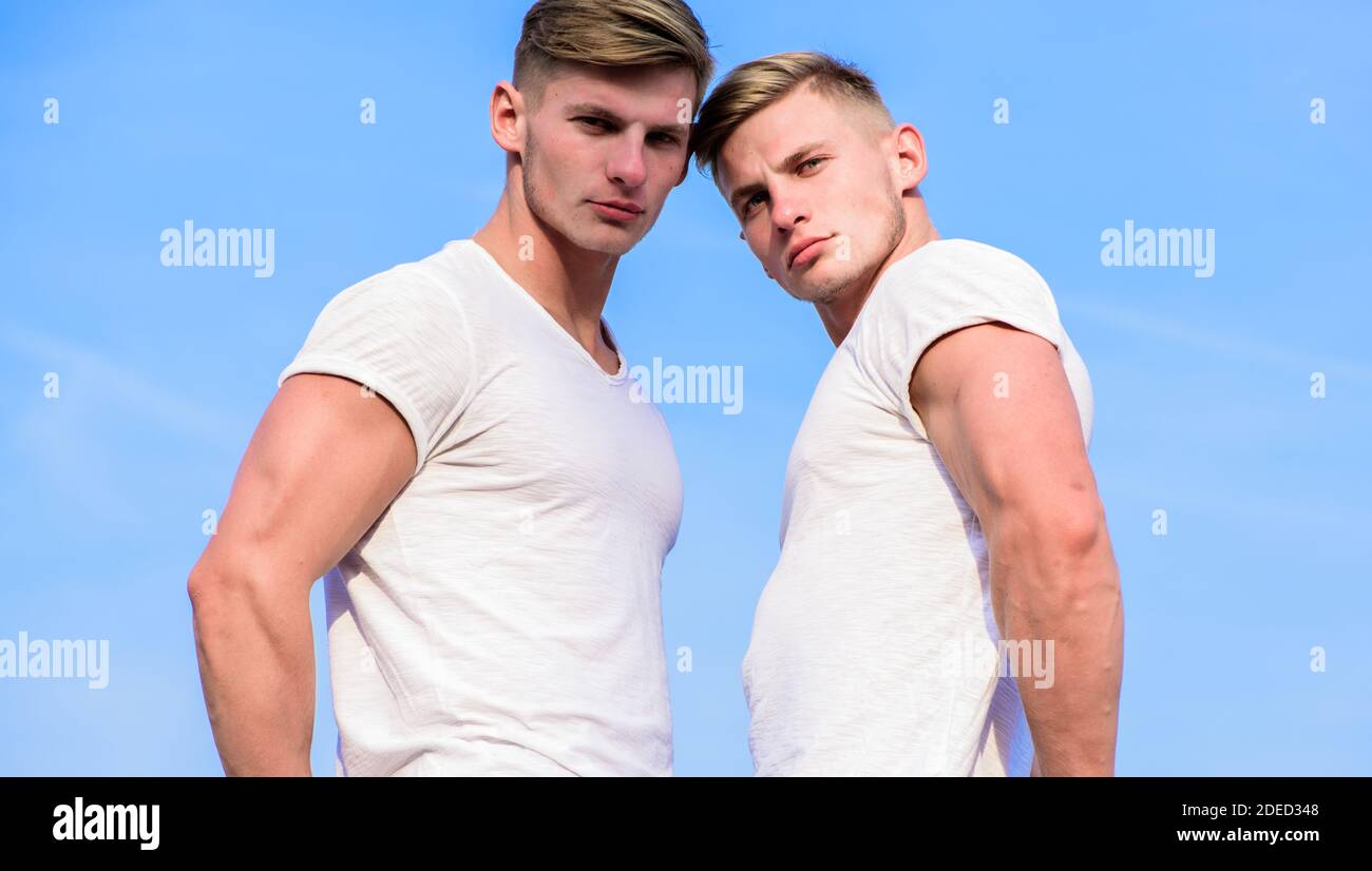 Men twins muscular brothers sky background. Handsome strong twins. Men ...