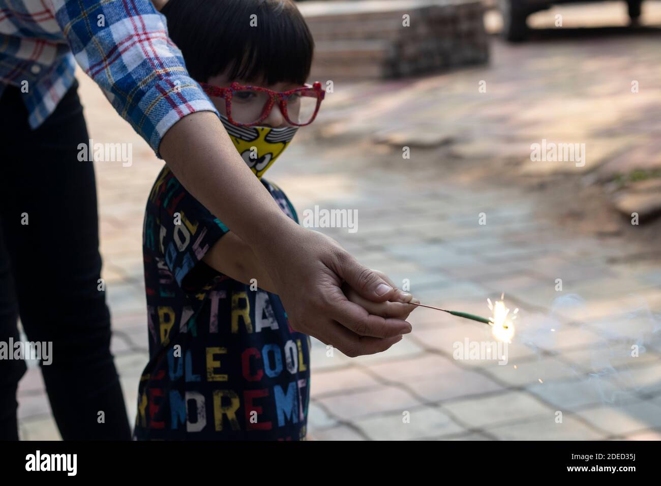 Indian cute boy playing with crackers, wearing mask Stock Photo - Alamy