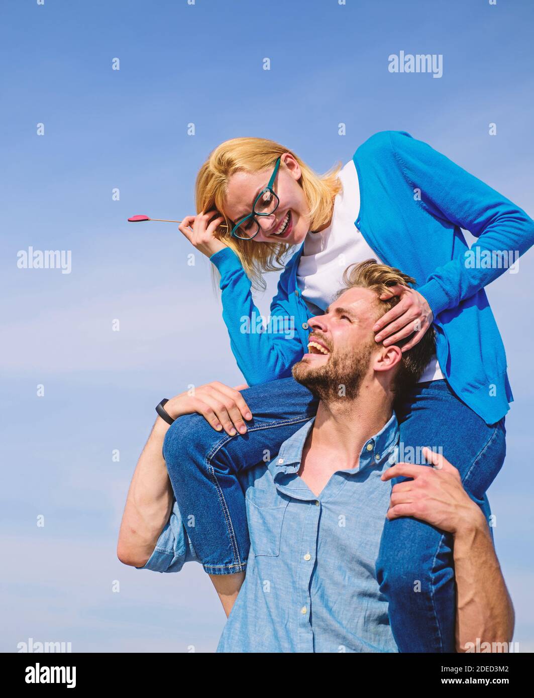Man carries girlfriend on shoulders, sky background. Woman enjoy ...