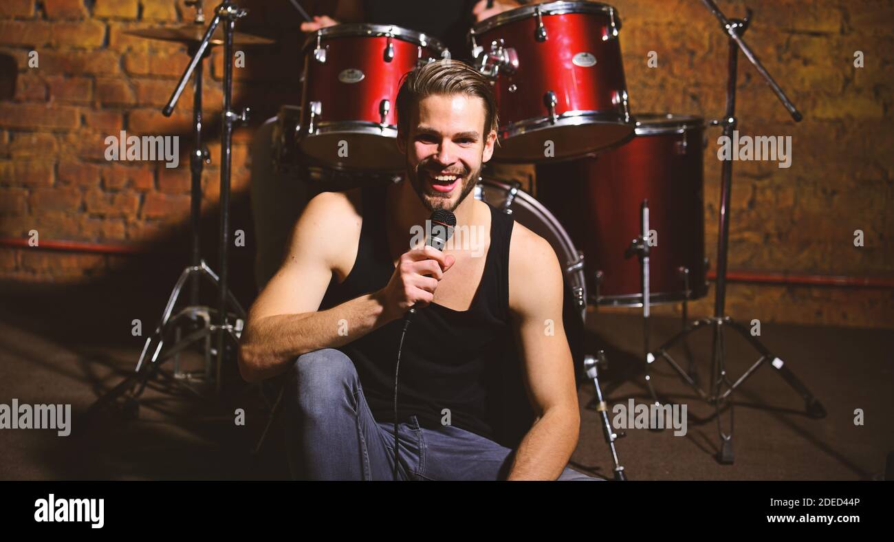 Singer with cheerful face sings sitting on scene. Rock music and ...