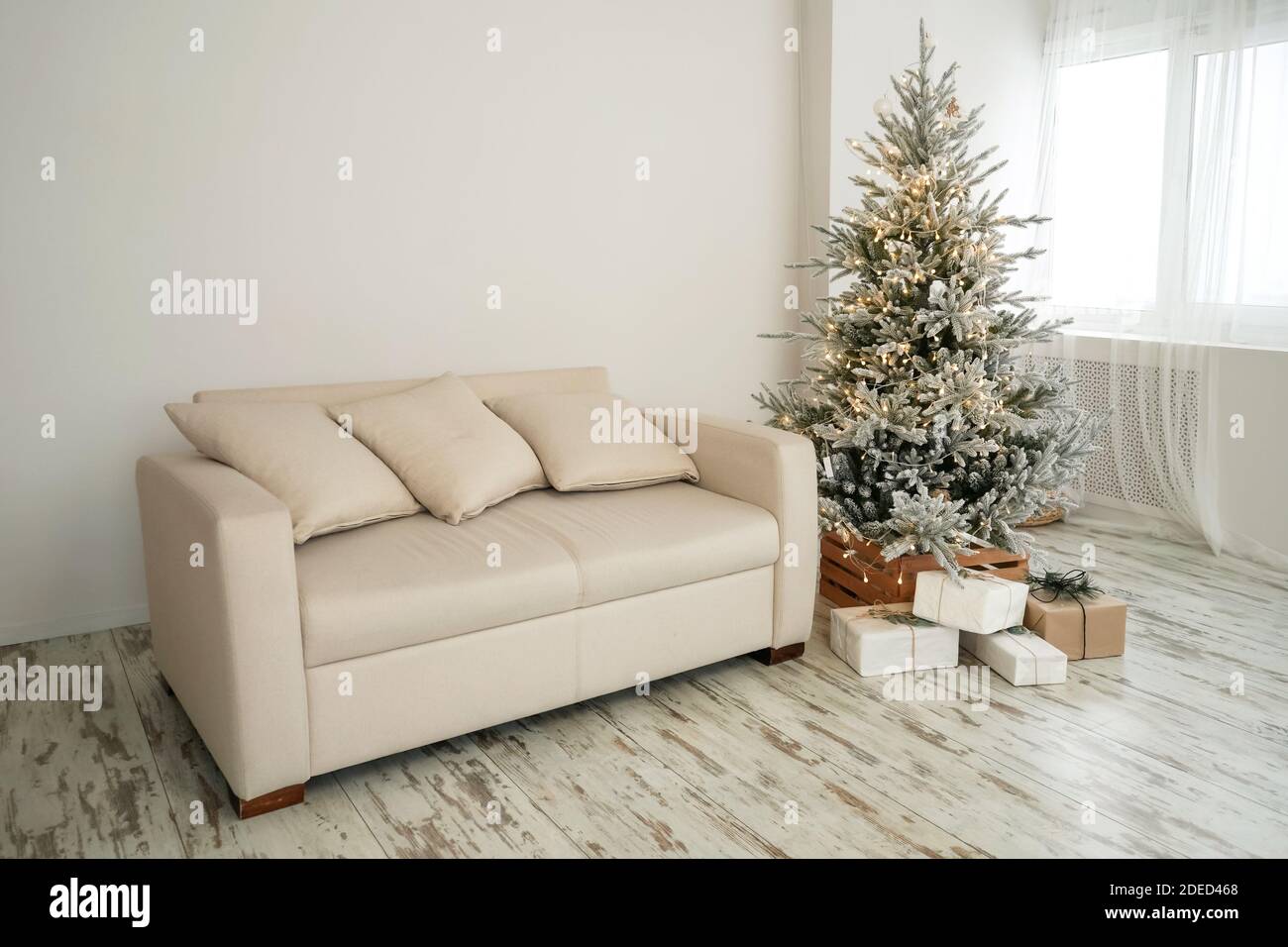 Christmas tree with presents underneath in living room, sofa. Light ...