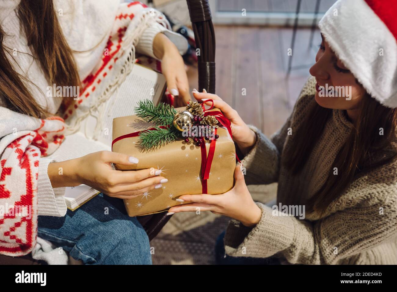 Two girls give gifts to each other on new year's eve Stock Photo - Alamy