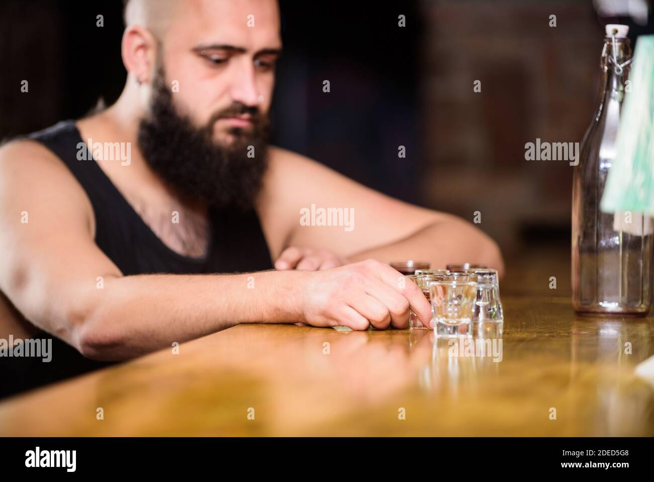 Hipster brutal man drinking alcohol ordering more drinks at bar counter ...