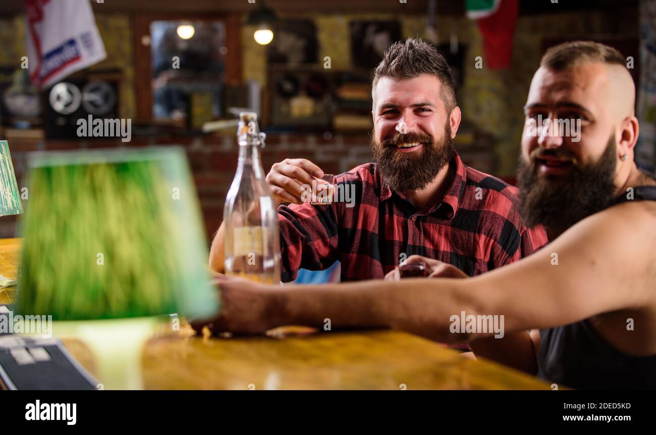 Strong alcohol drinks. Friends relaxing in pub. Alcohol addiction. Men ...