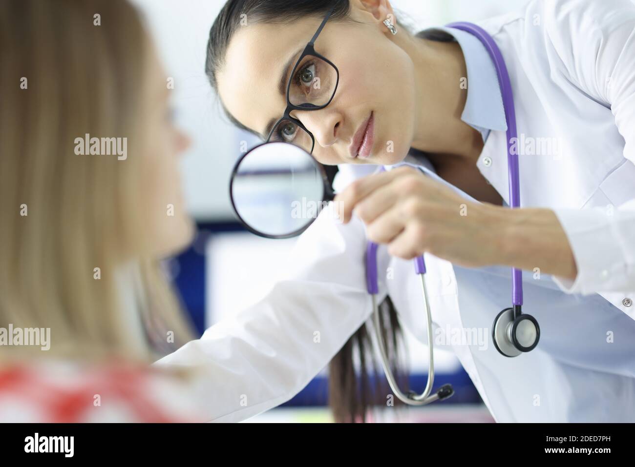 Doctor examines the patient's face through magnifying glass Stock Photo ...