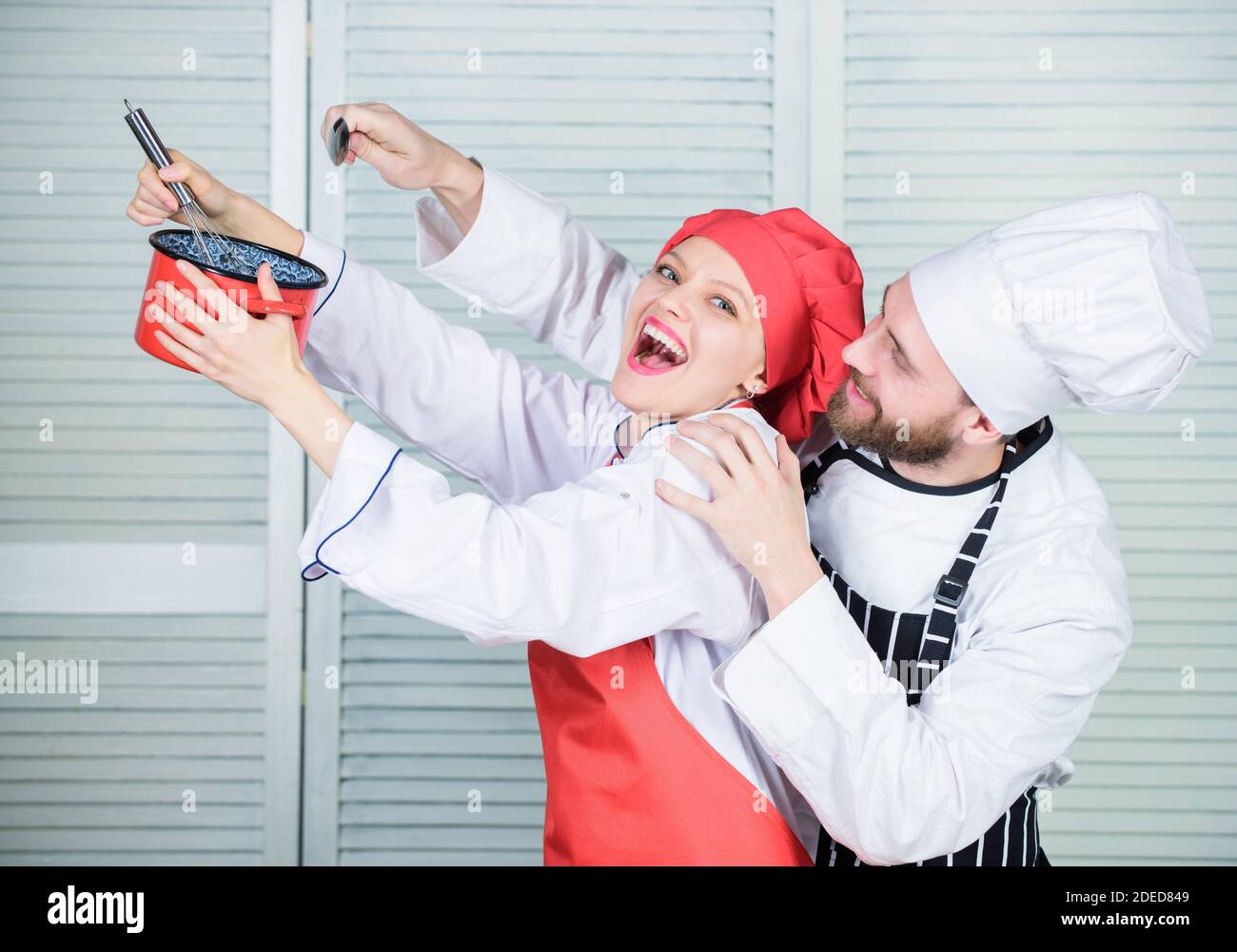 Cooking together is more fun. Let my try taste. Couple having fun while ...