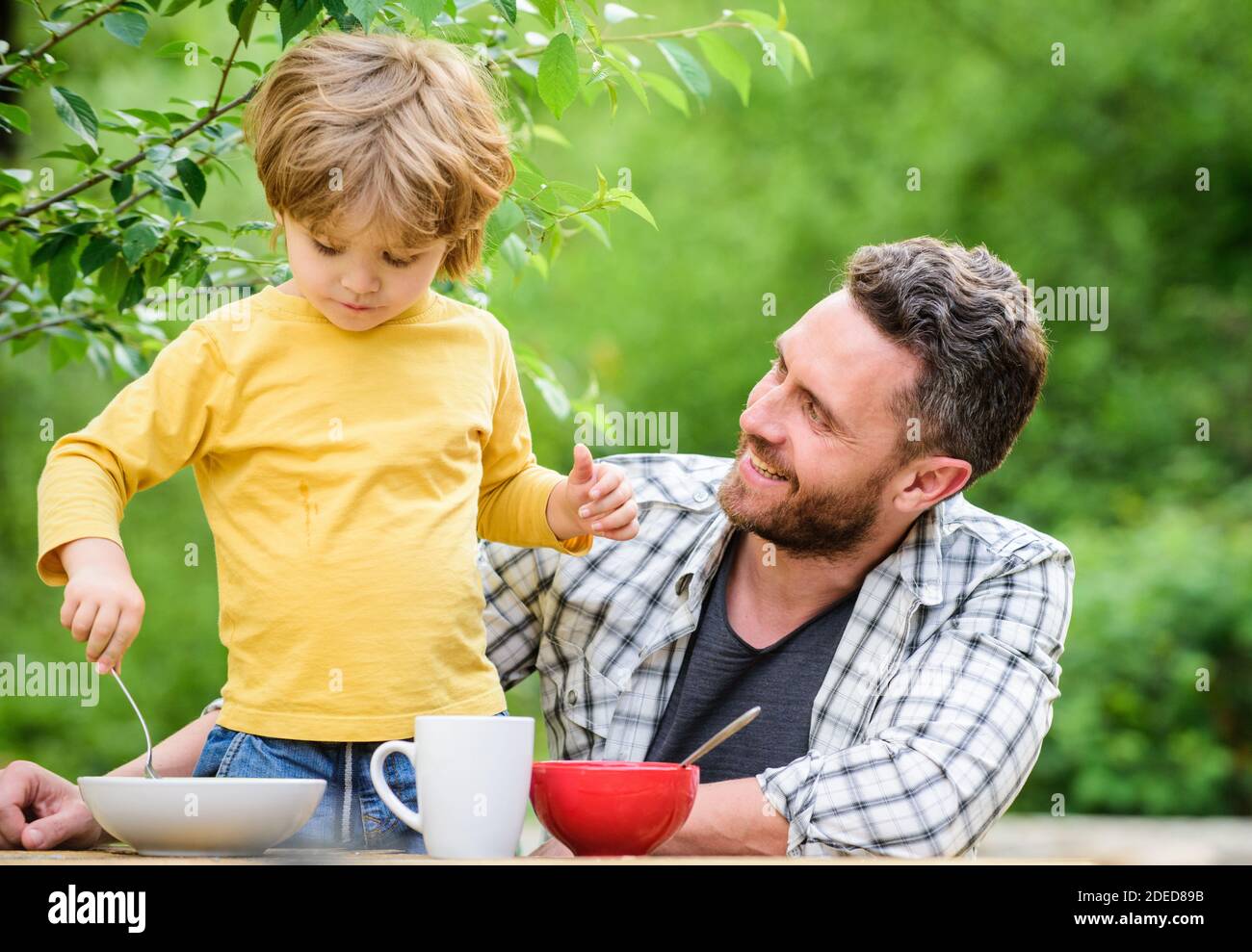 Food habits. Little boy with dad eating food picnic yard nature ...