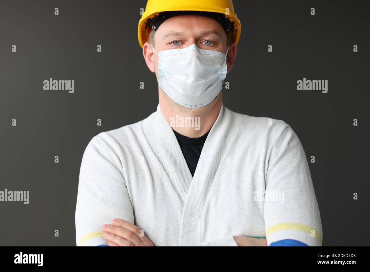 Male construction worker in yellow caste and medical protective mask ...