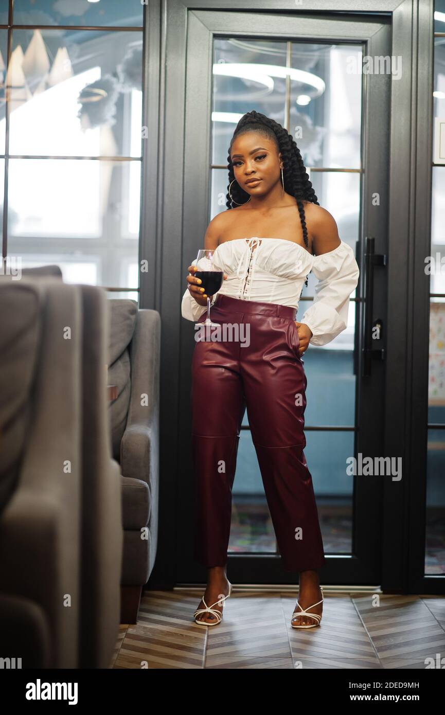 Beautiful african american woman in white blouse and red leather pants ...