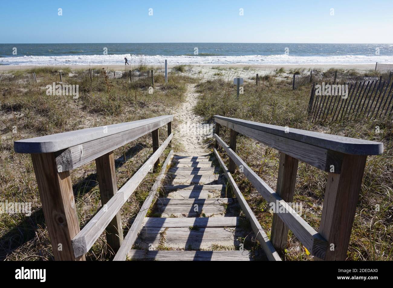 A beautiful scenery of a wooden pathway leading to the beach for a ...