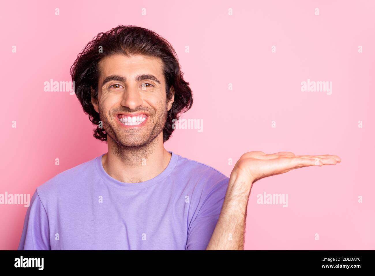 Close up portrait of young guy smile arm palm showing product purple ...