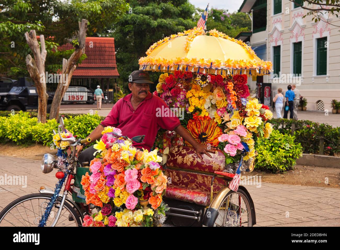A very decorative and colourful pedal trishaw with garlands of ...