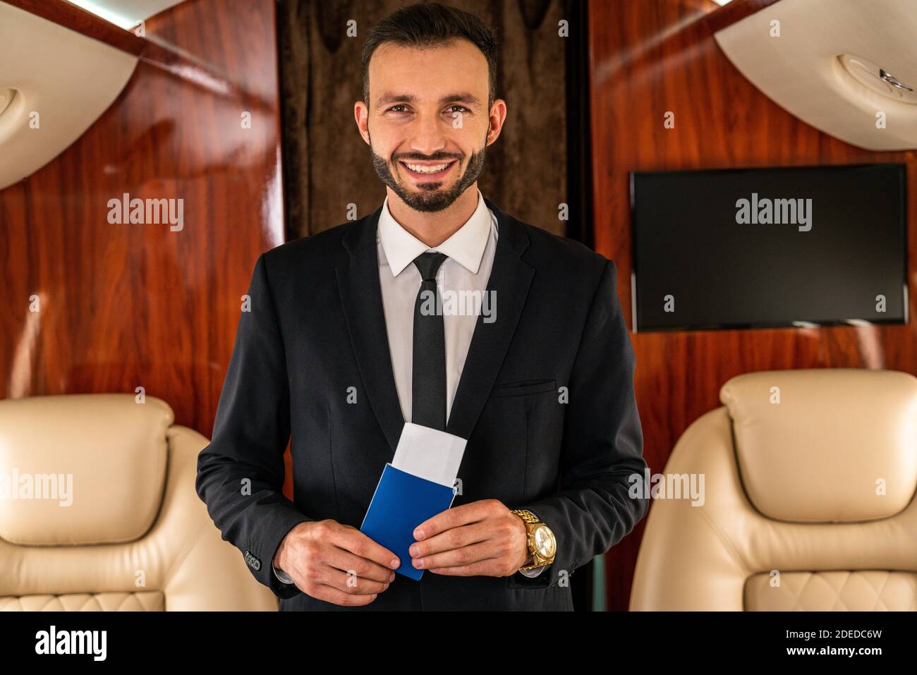 Handsome businessman wearing elegant suit flying on exclusive private ...