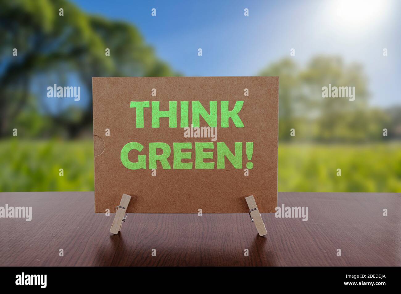 Think green text on card on the table with sunny green park background ...