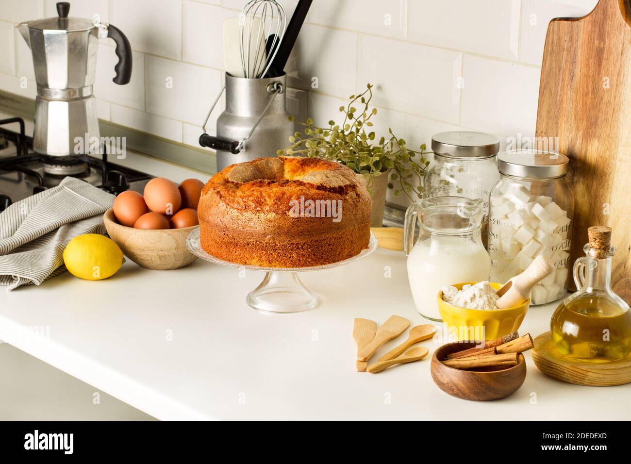 A vanilla cake and ingredients on a cake stand on the kitchen ...