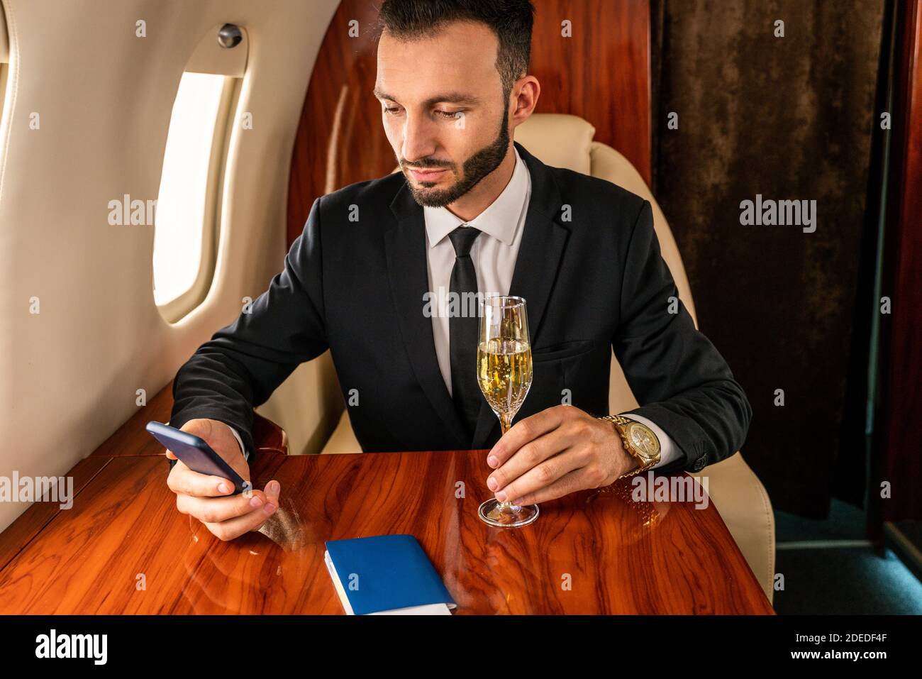Handsome businessman wearing elegant suit flying on exclusive private ...