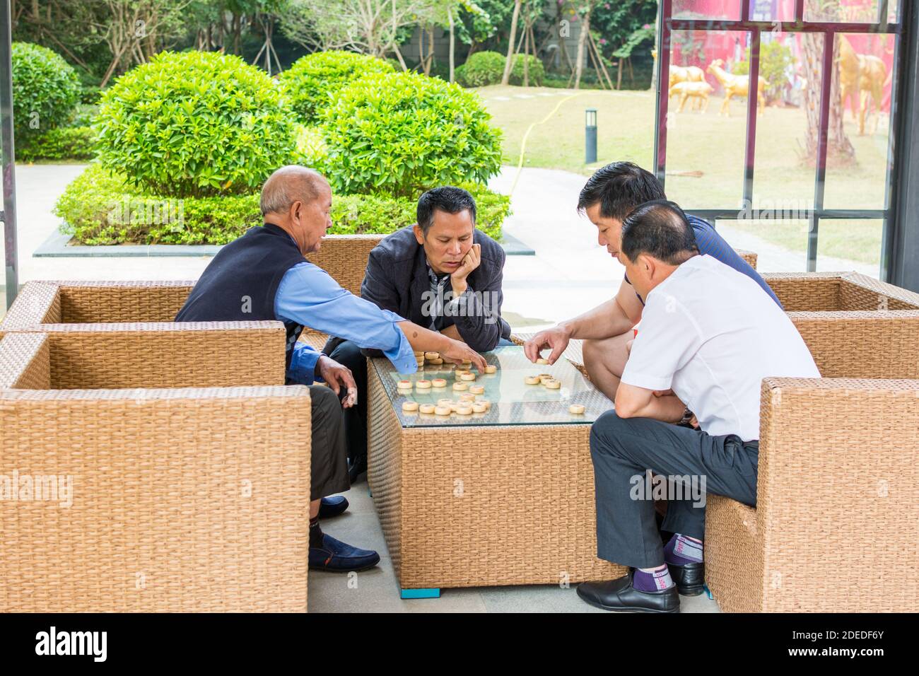 Four Chinese men playing Chinese chess in a park in Shenzhen, China ...