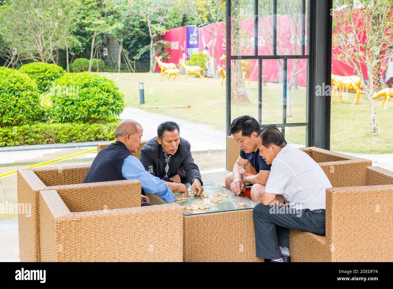 Four Chinese men playing Chinese chess in a park in Shenzhen, China ...