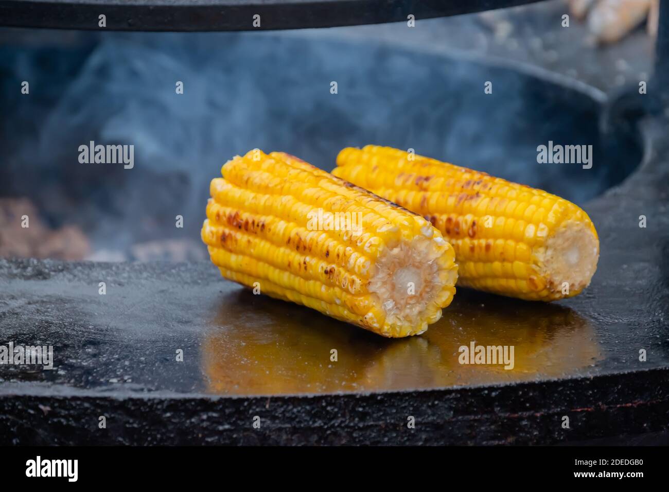 Process of grilling healthy yellow corn on brazier at street food ...