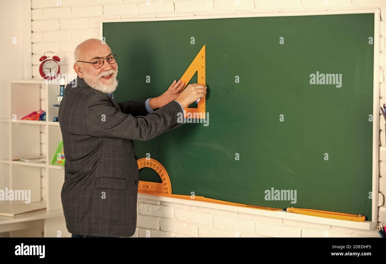 tutor man in glasses draw with triangle on blackboard. back to school ...