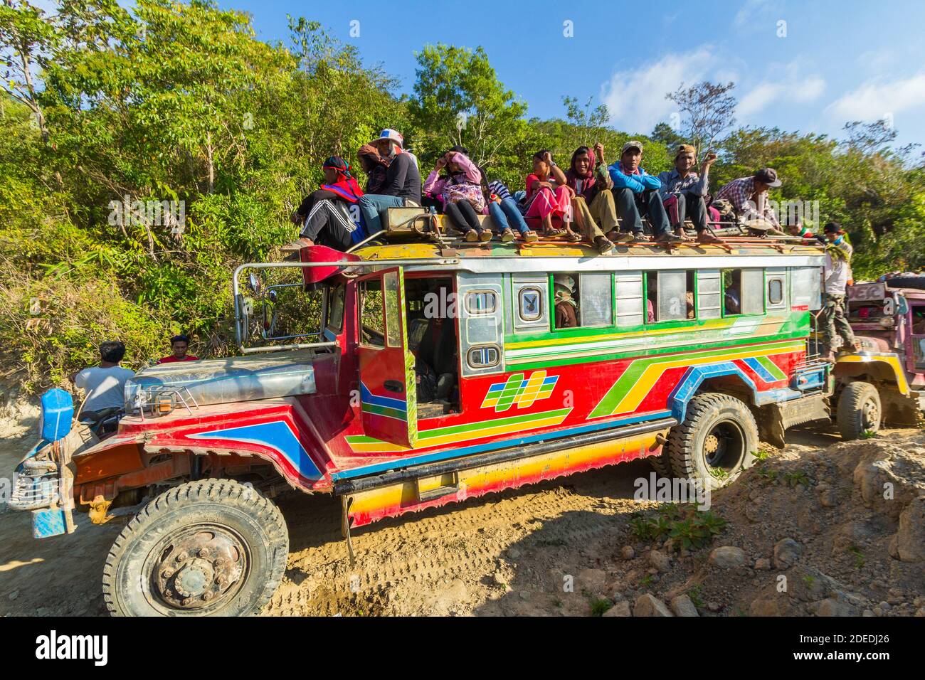 An overloaded jeepney with people occupying the roof in at mountain ...