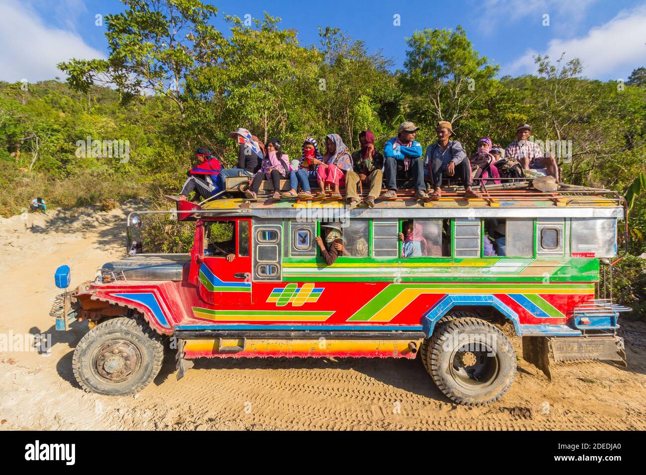 An overloaded jeepney with people occupying the roof in at mountain ...