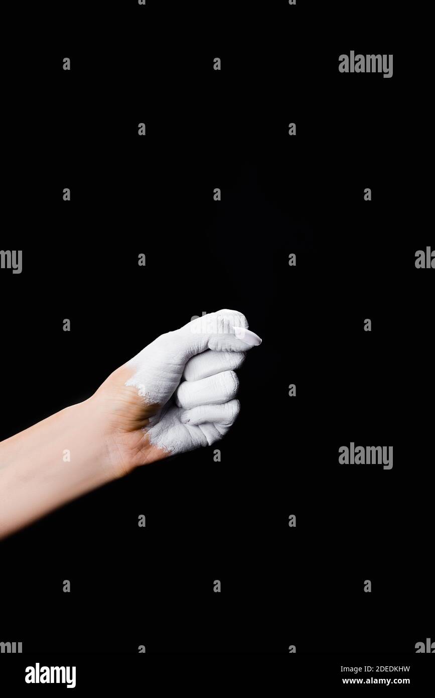 partial view of white painted fist isolated on black Stock Photo - Alamy