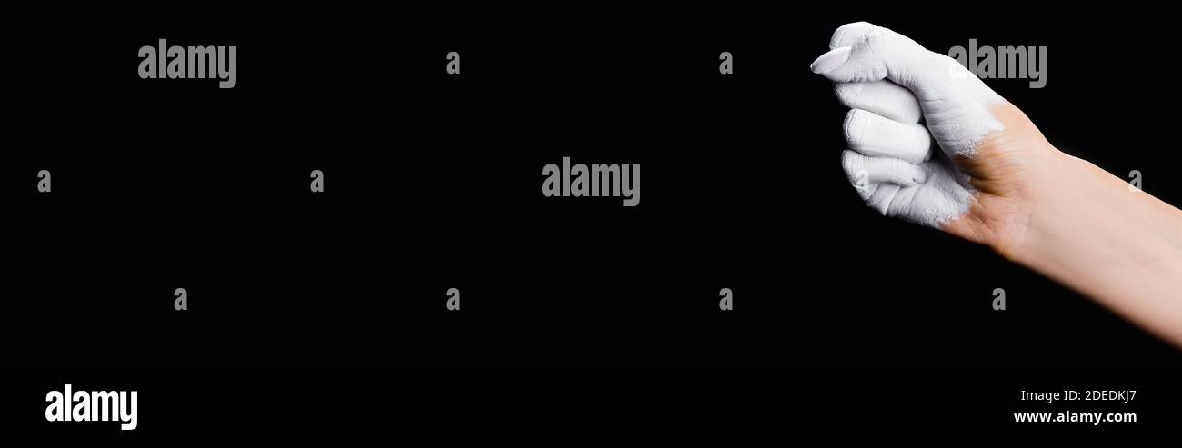 partial view of white painted fist isolated on black, banner Stock ...